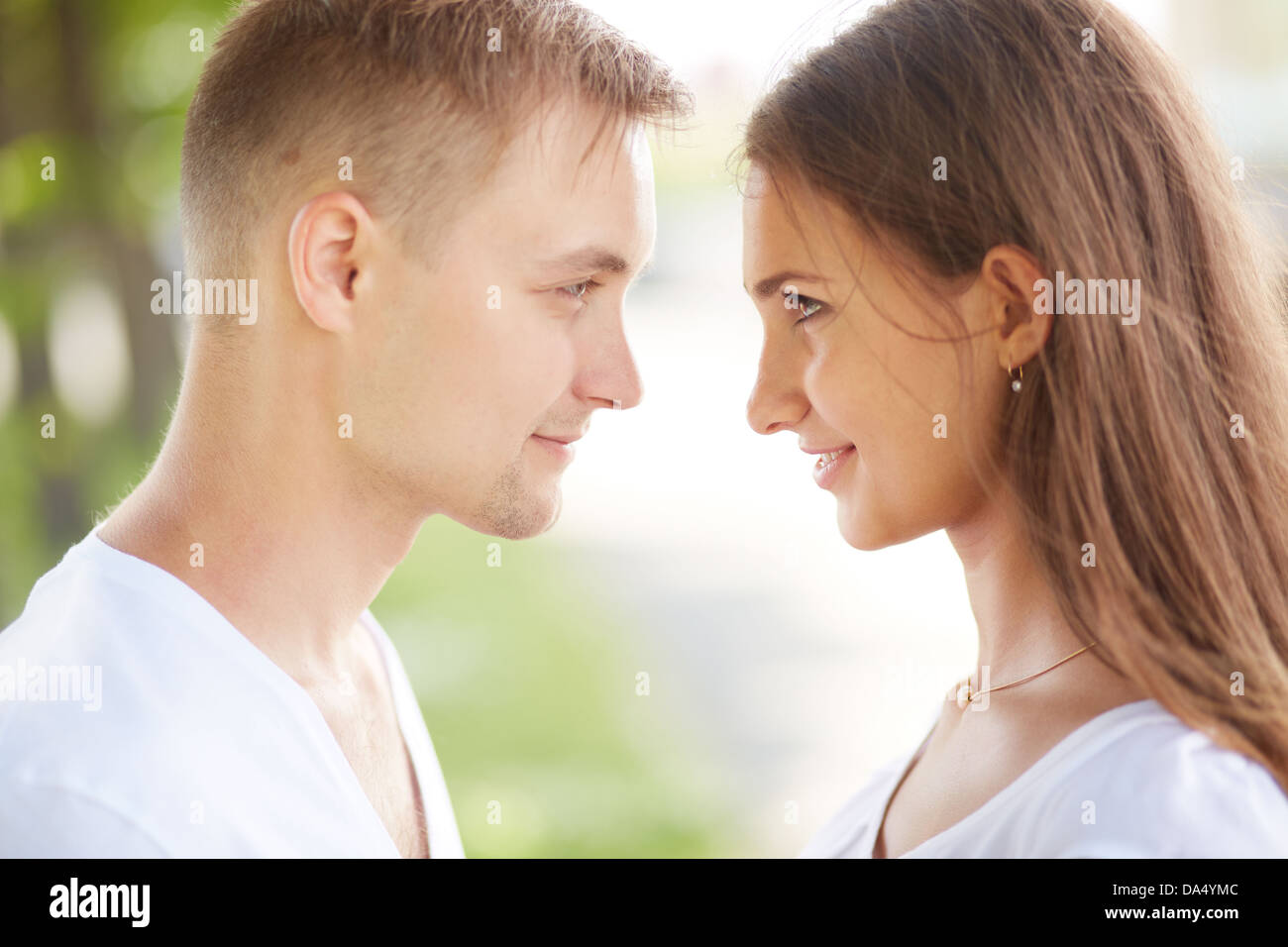 Happy girl and her boyfriend looking at one another Stock Photo - Alamy