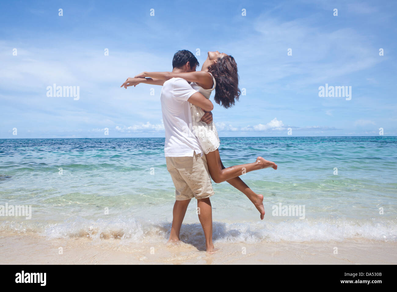 A young couple posing by the sea Stock Photo - Alamy