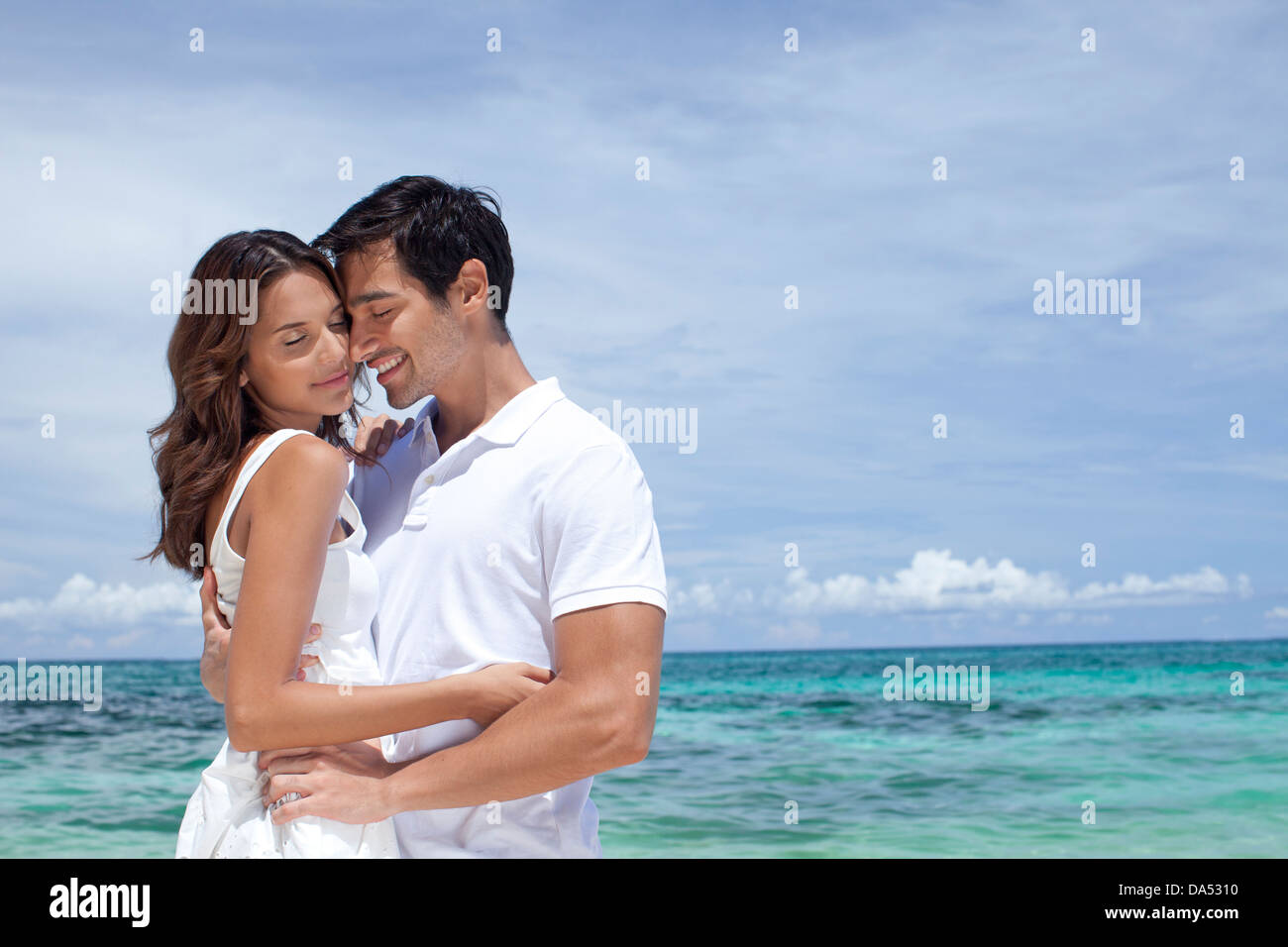 A young couple posing by the sea Stock Photo - Alamy