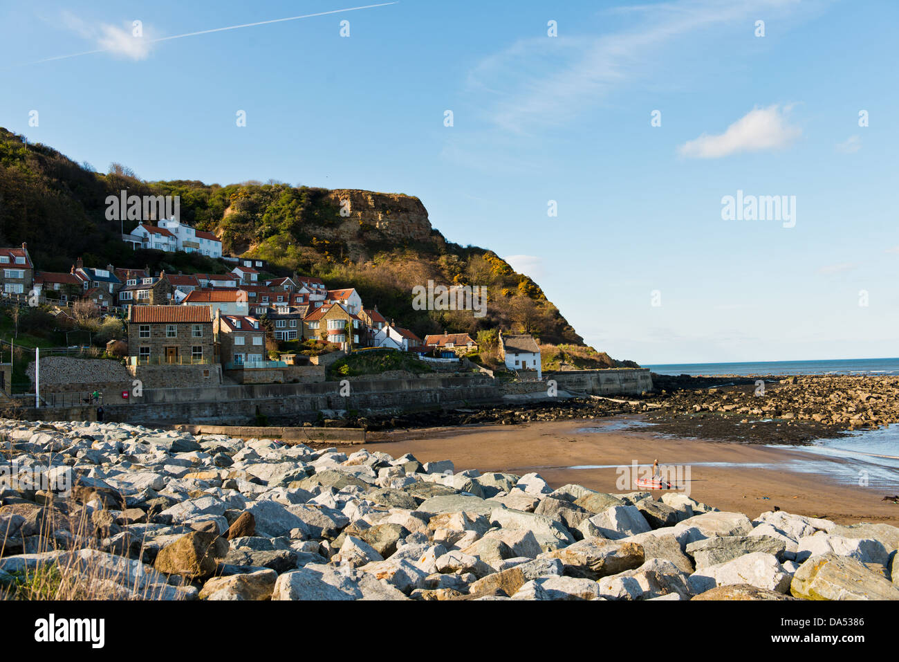 A view of Runswick Bay from the beach with a blue sky, North Yorkshire ...