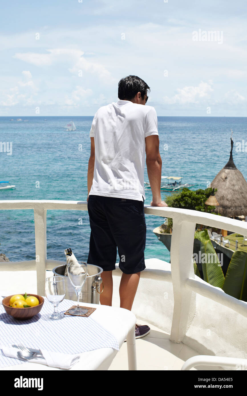 A young man standing on a balcony Stock Photo - Alamy