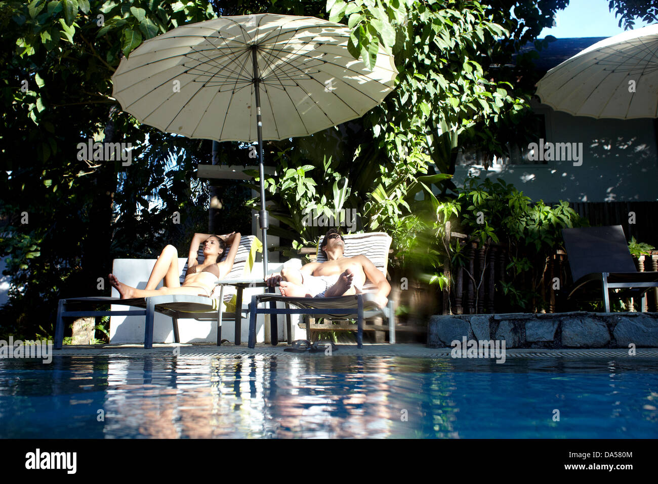A couple relaxing poolside Stock Photo - Alamy