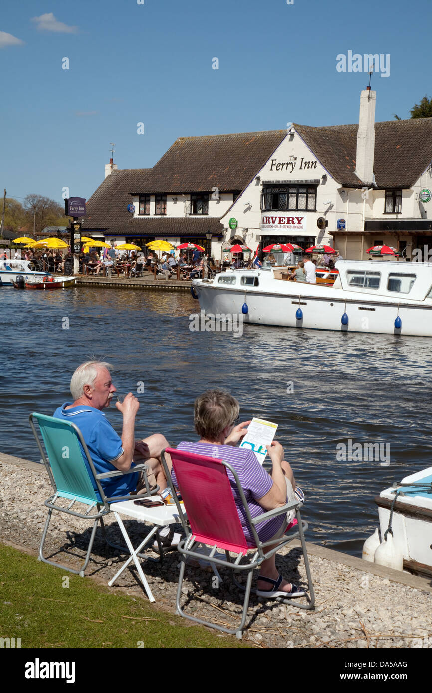People sitting on the bank of the river Bure opposite the Ferry Inn at ...