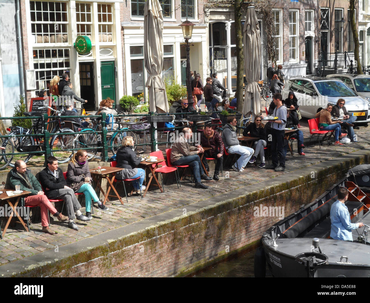 Locals and tourists enjoy the spring sun in a typical canal cafe in ...