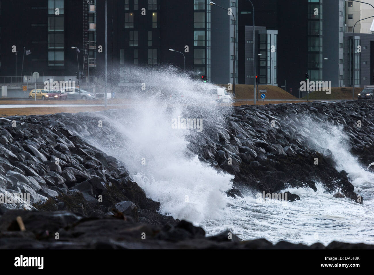 Waves crashing up to the road during a storm in Reykjavik, Iceland ...