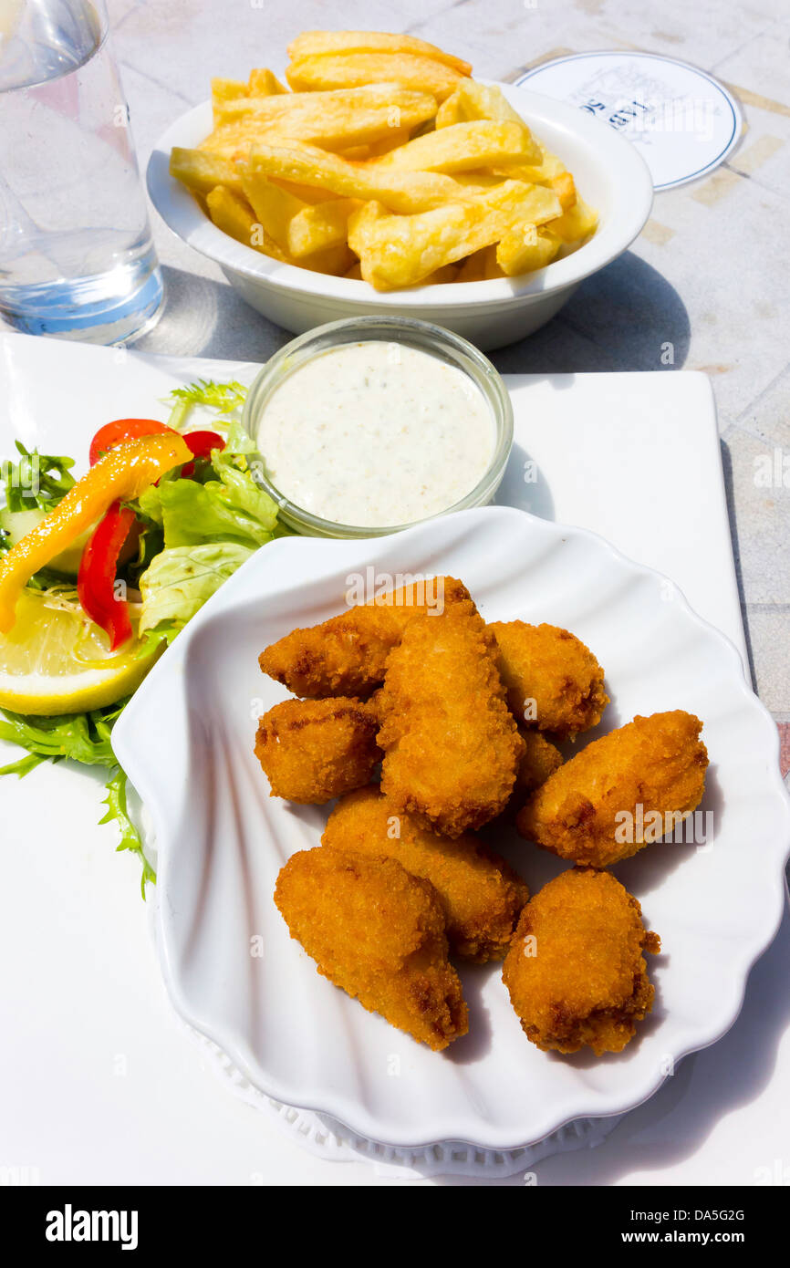A simple pub lunch of breaded Scampi with tartare sauce lemon, salad ...