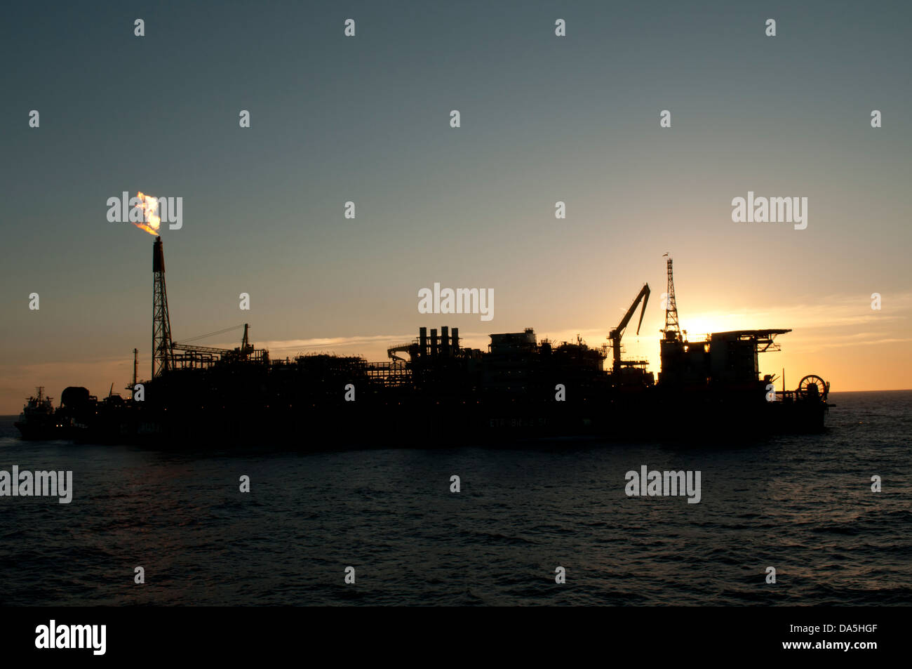 silhouette of an offshore FPSO oil rig at sunset/sunrise dusk time ...