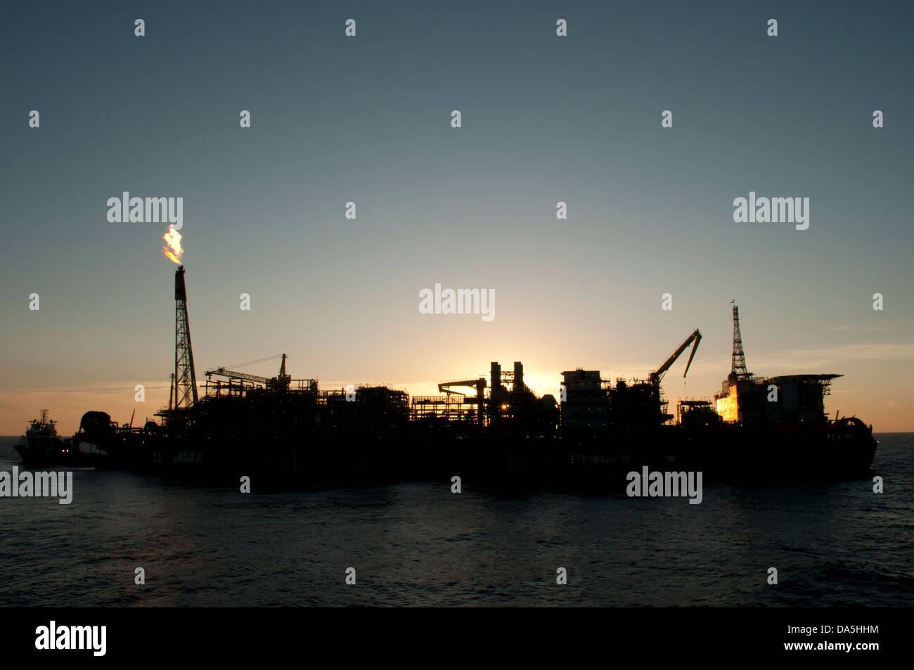 silhouette of an offshore FPSO oil rig at sunset/sunrise dusk time ...