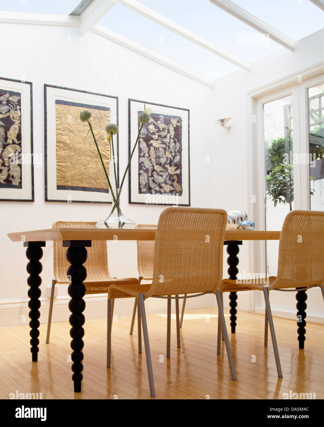 Wicker chairs at wooden table with spindle legs in modern dining room ...