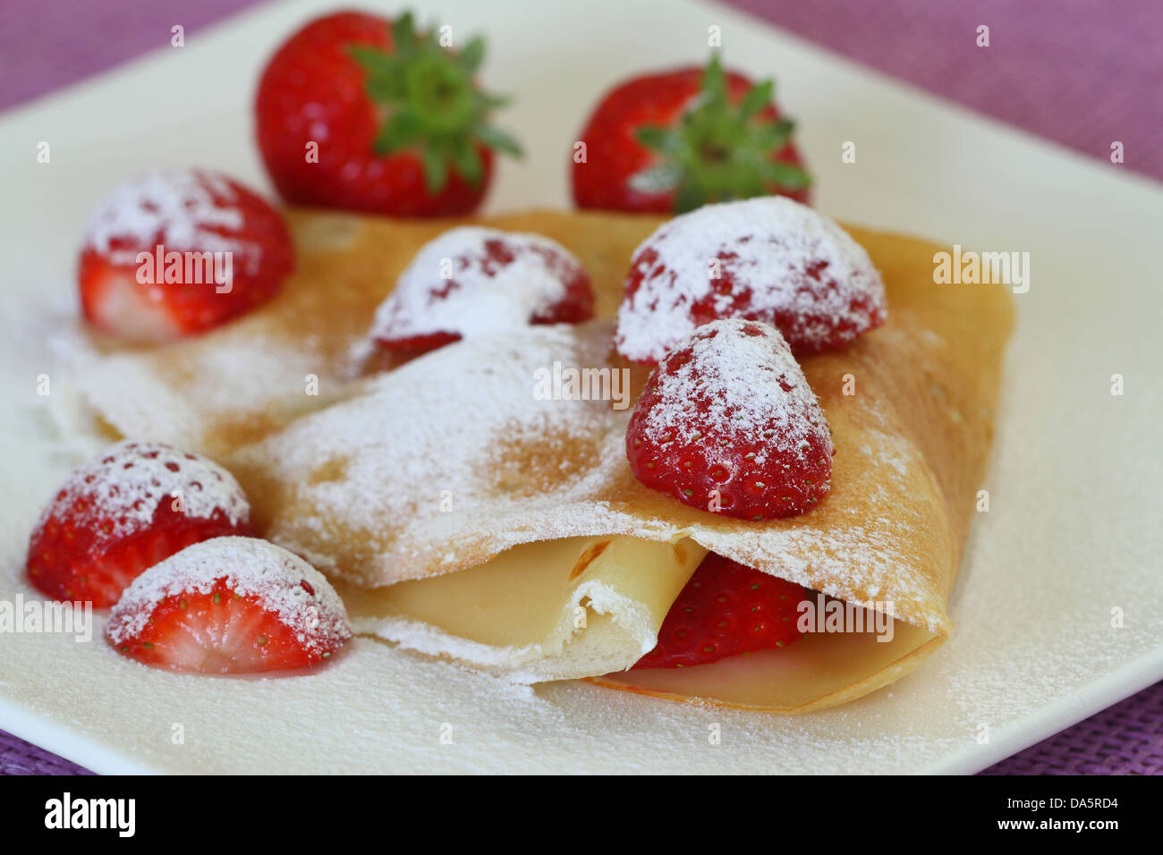 Crepe with strawberries dusted with icing sugar Stock Photo - Alamy
