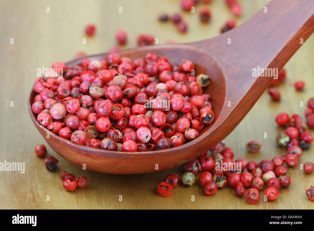 Red peppers in wooden spoon, close up Stock Photo - Alamy