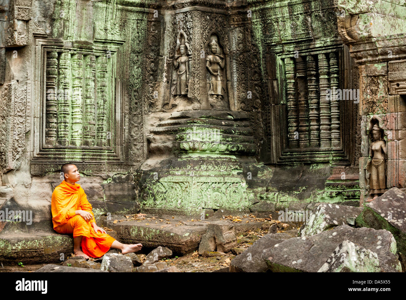 Monk sitting in an ancient temple with carvings Stock Photo - Alamy