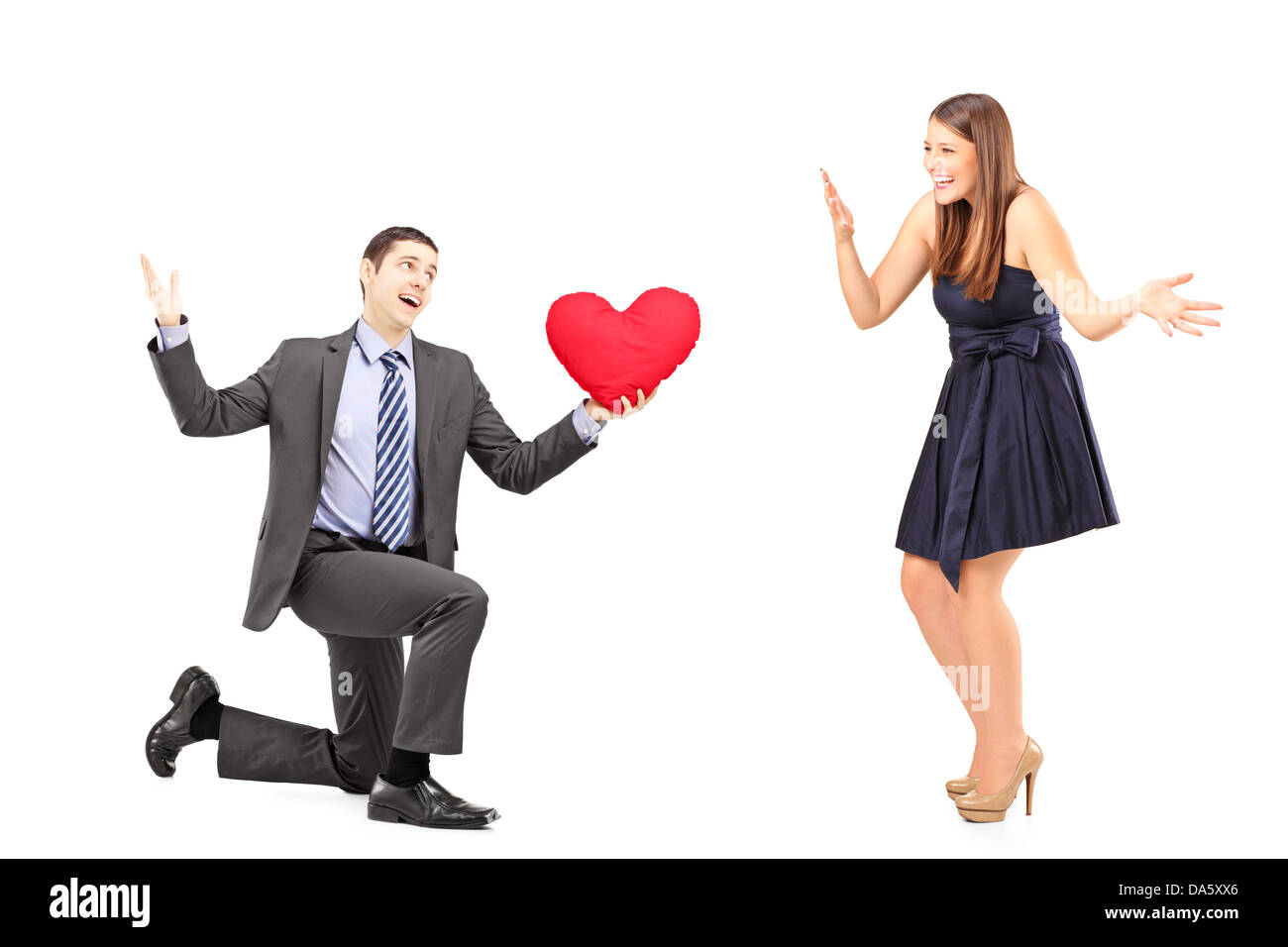 Romantic man giving a red heart to a young woman, isolated on white ...