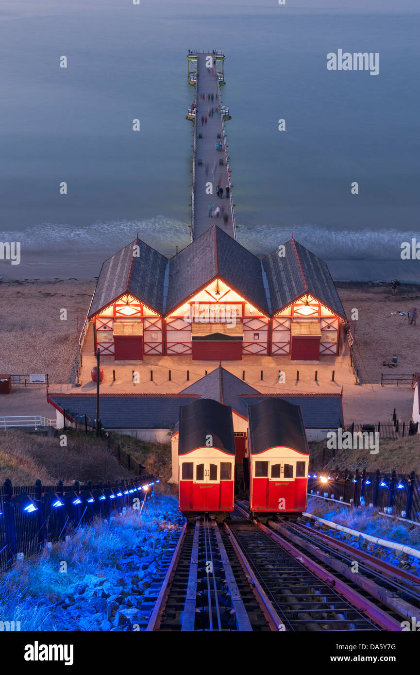 Summer evening high view over Saltburn's illuminated cliff lift, people ...
