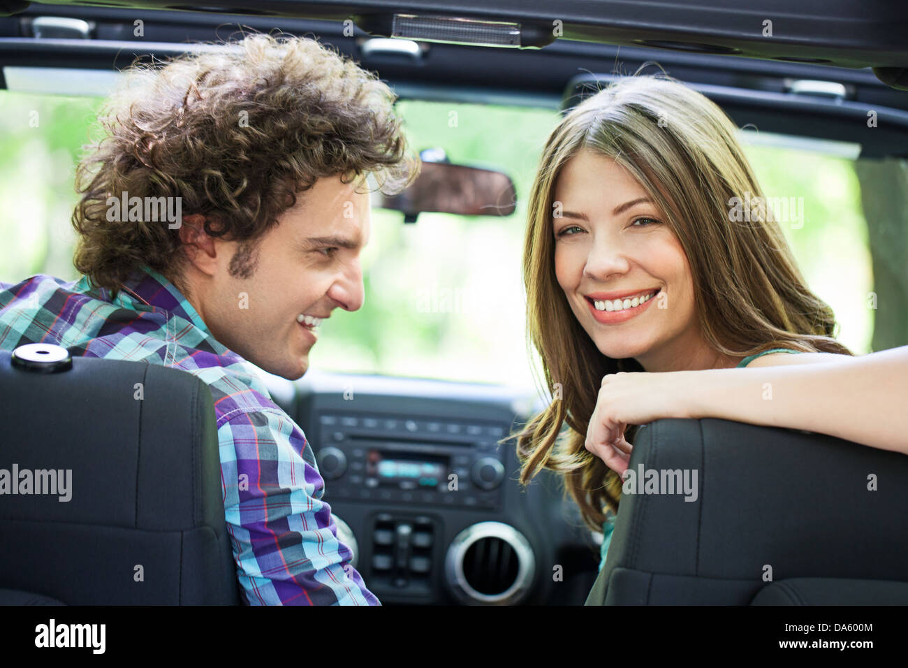 Attractive young romantic couple enjoying in driving through the nature ...