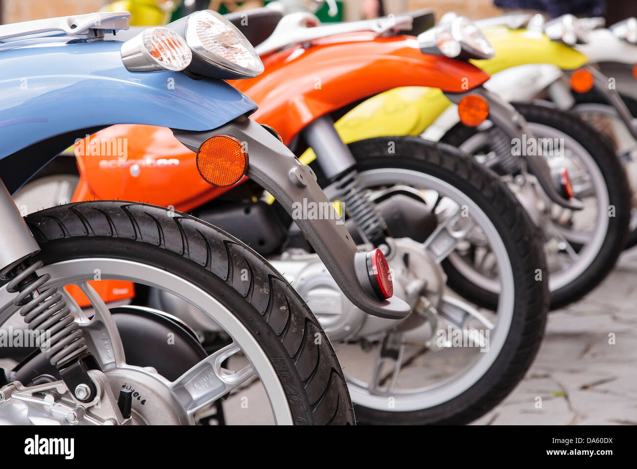 The wheels of four colourful mopeds in Italy Stock Photo - Alamy