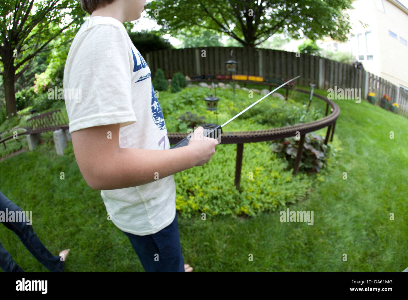 Boy holding a remote control box and moving a miniature model train on ...