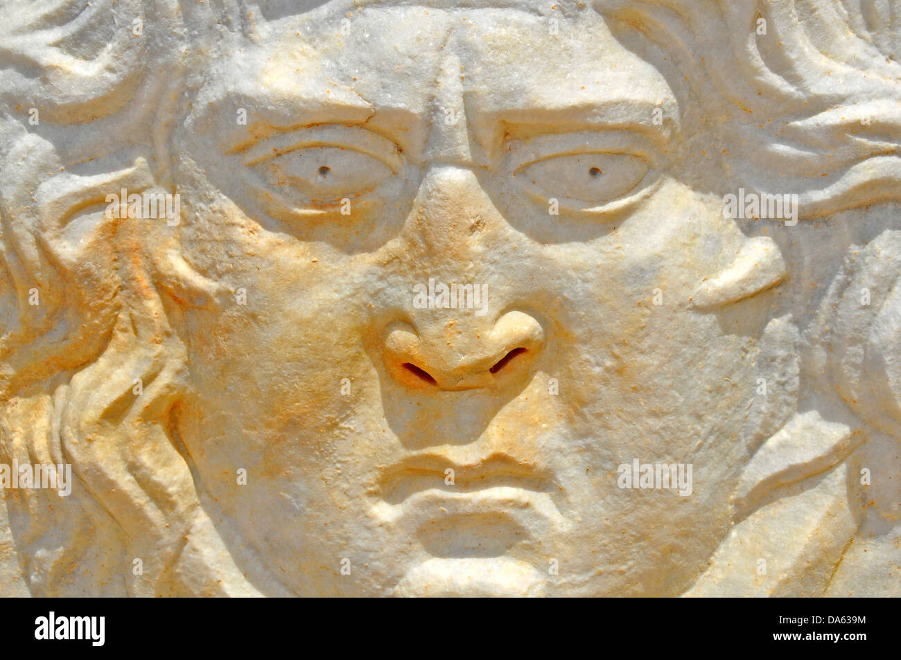 Face of a sad or angry man with long hair carved in marble, by an ...