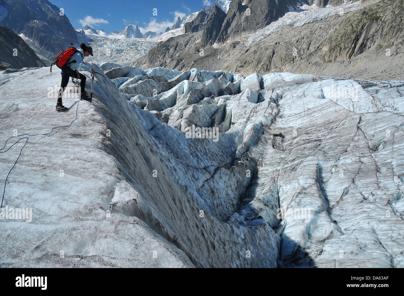 woman alpinist attached on a rope on the edge of a huge crevasse in an ...