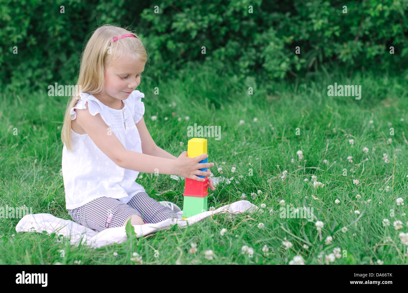Little girl playing blocks in the park Stock Photo - Alamy