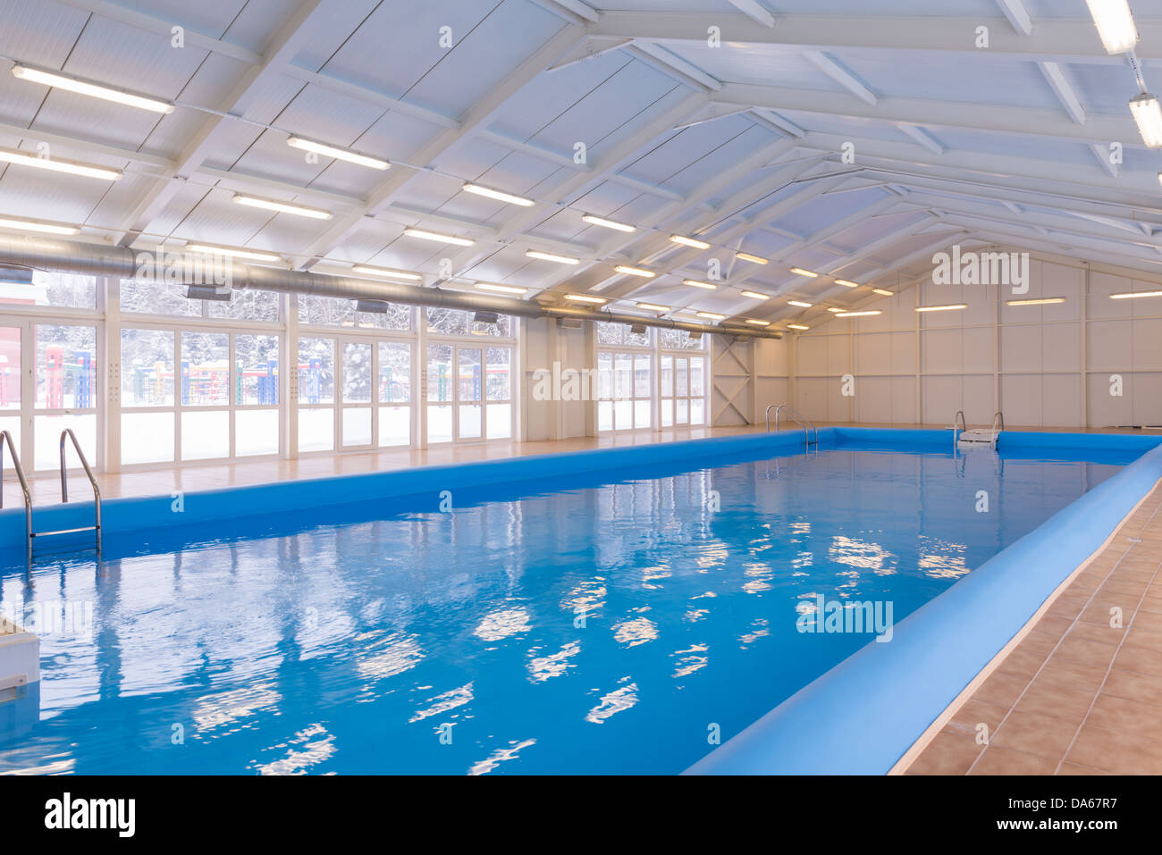 Indoors swimming pool with blue water Stock Photo - Alamy