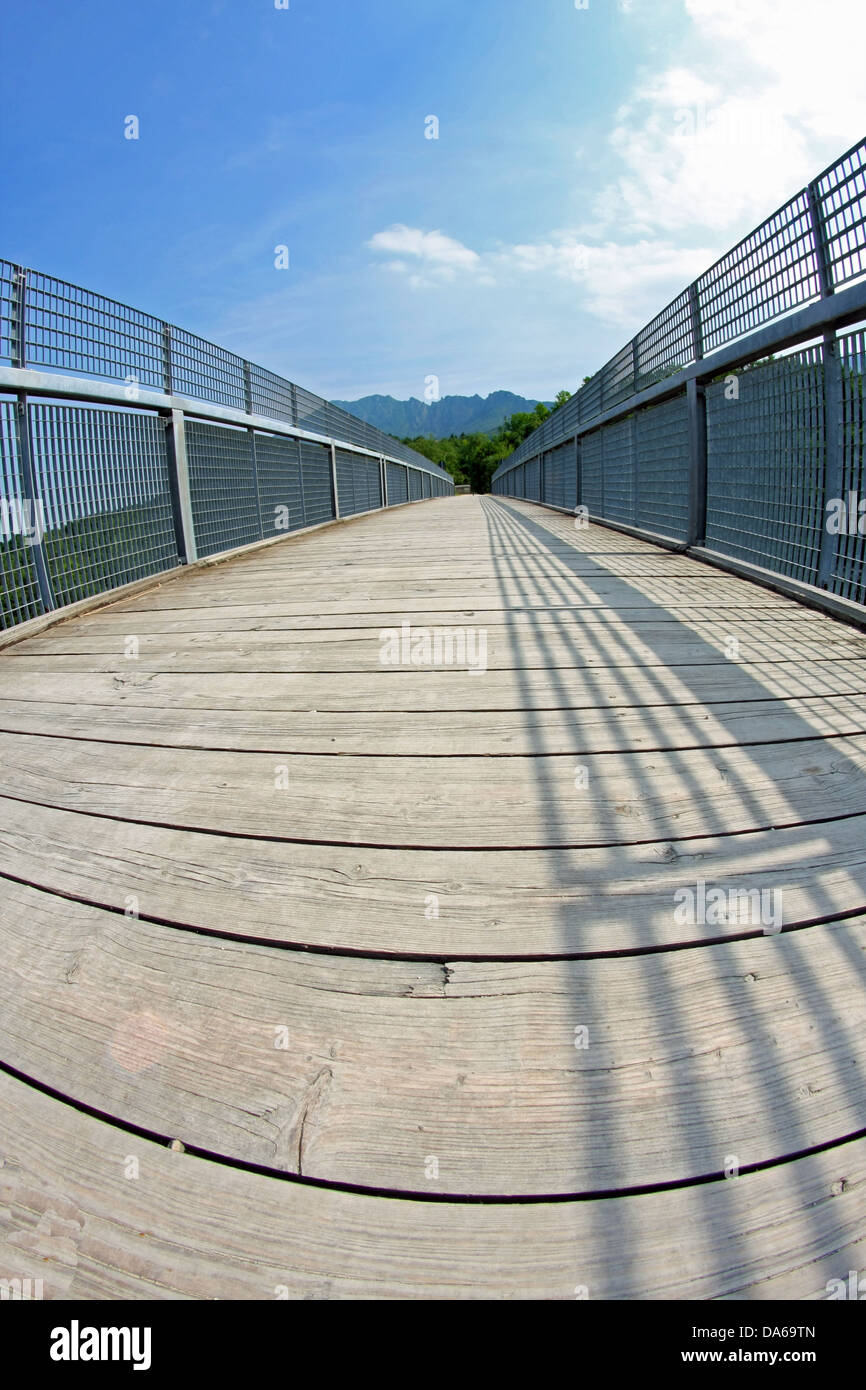 long bridge with a wooden walkway and handrail made of galvanized steel ...