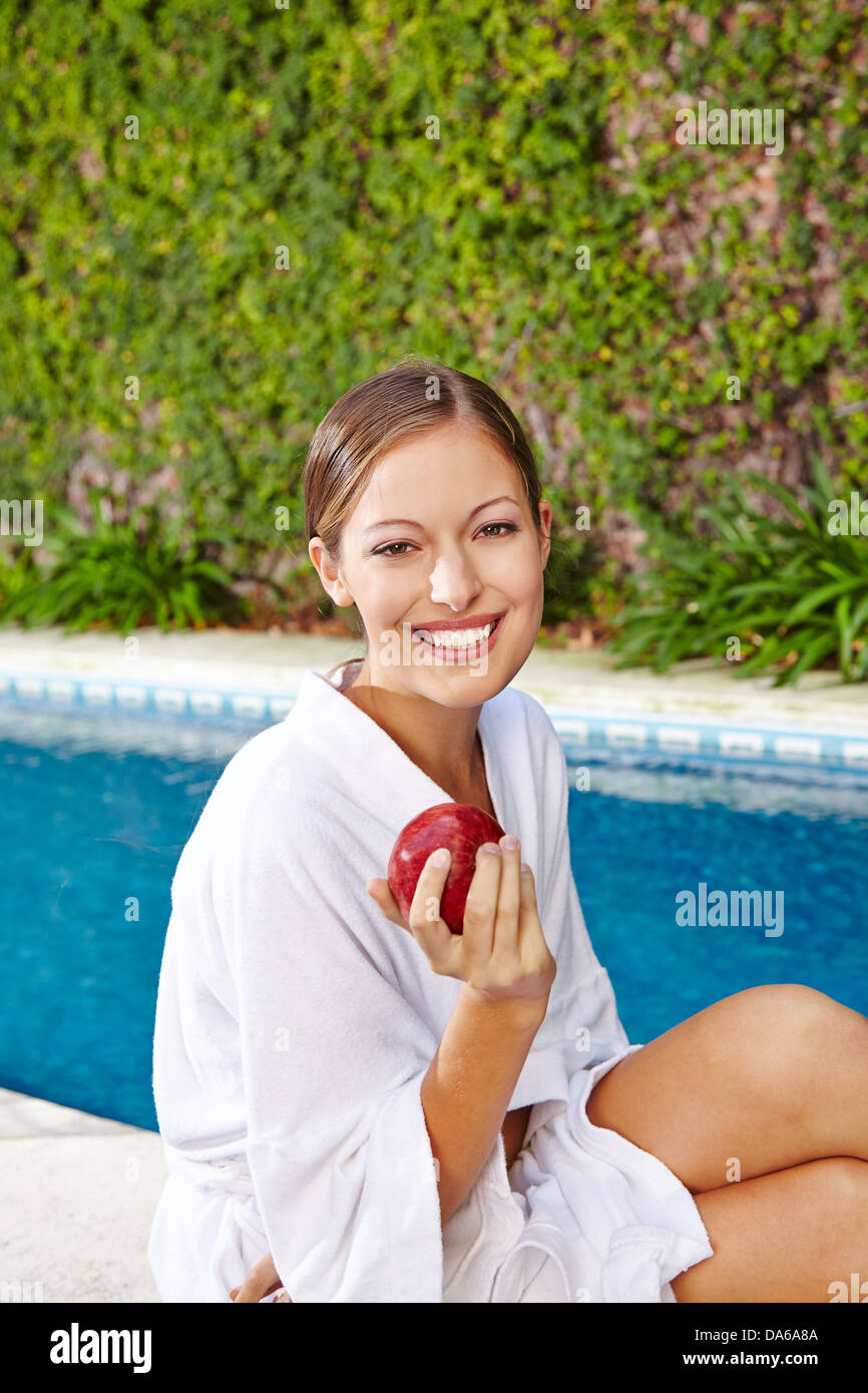 Young attractive woman with red apple at swimming pool Stock Photo - Alamy