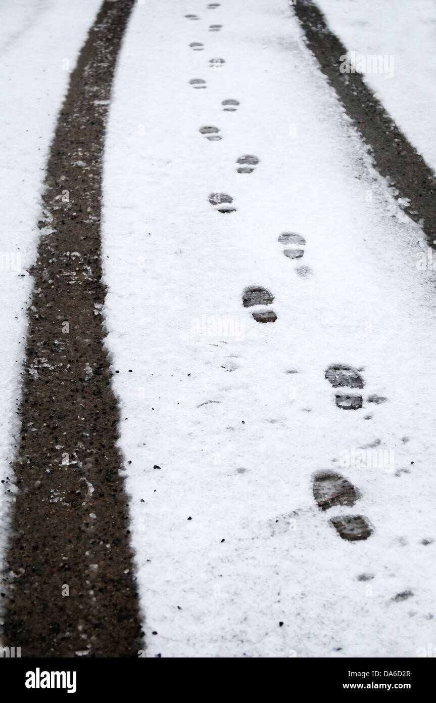 Tire tracks and footprints in snowy road hi-res stock photography and ...