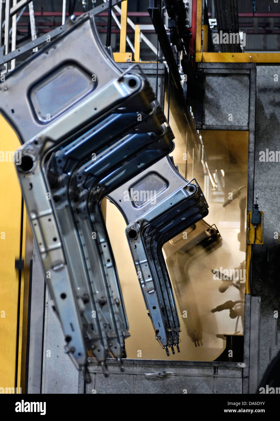 Metal structures of car seats are pulled through a painting system at a ...