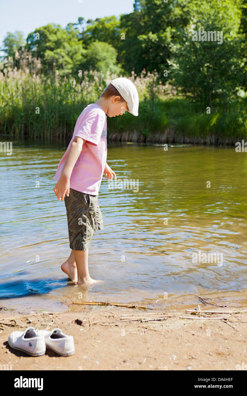 Boy (8-9) wading in water Stock Photo - Alamy