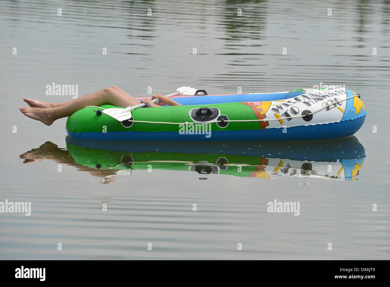 A youth lies in a rubber raft on a bathing lake in Gernsheim, Germany ...