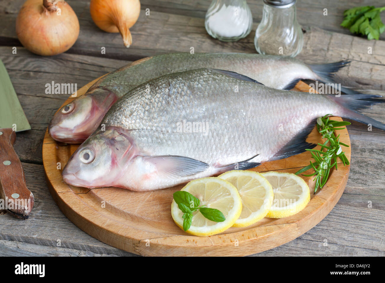 Bream raw fish on cutting board in the kitchen with spices Stock Photo ...