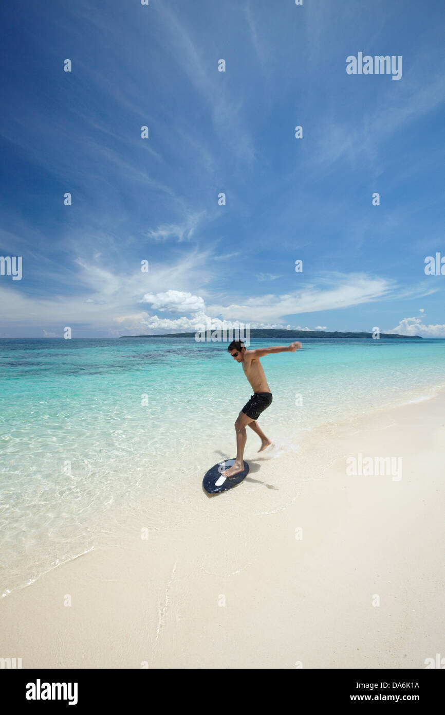A man playing on a surfboard Stock Photo - Alamy