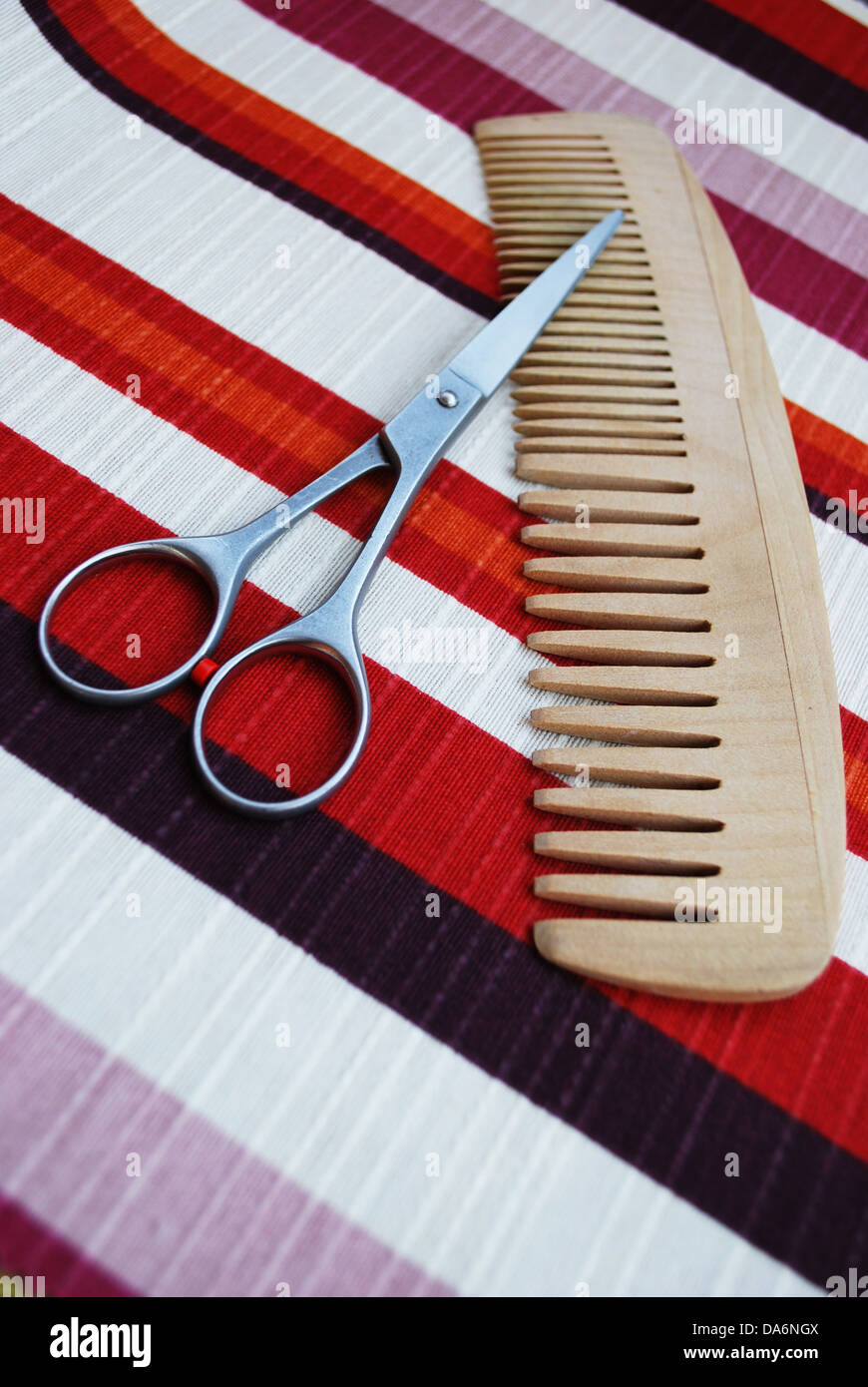 Professional scissors and wooden comb on colorful background Stock ...