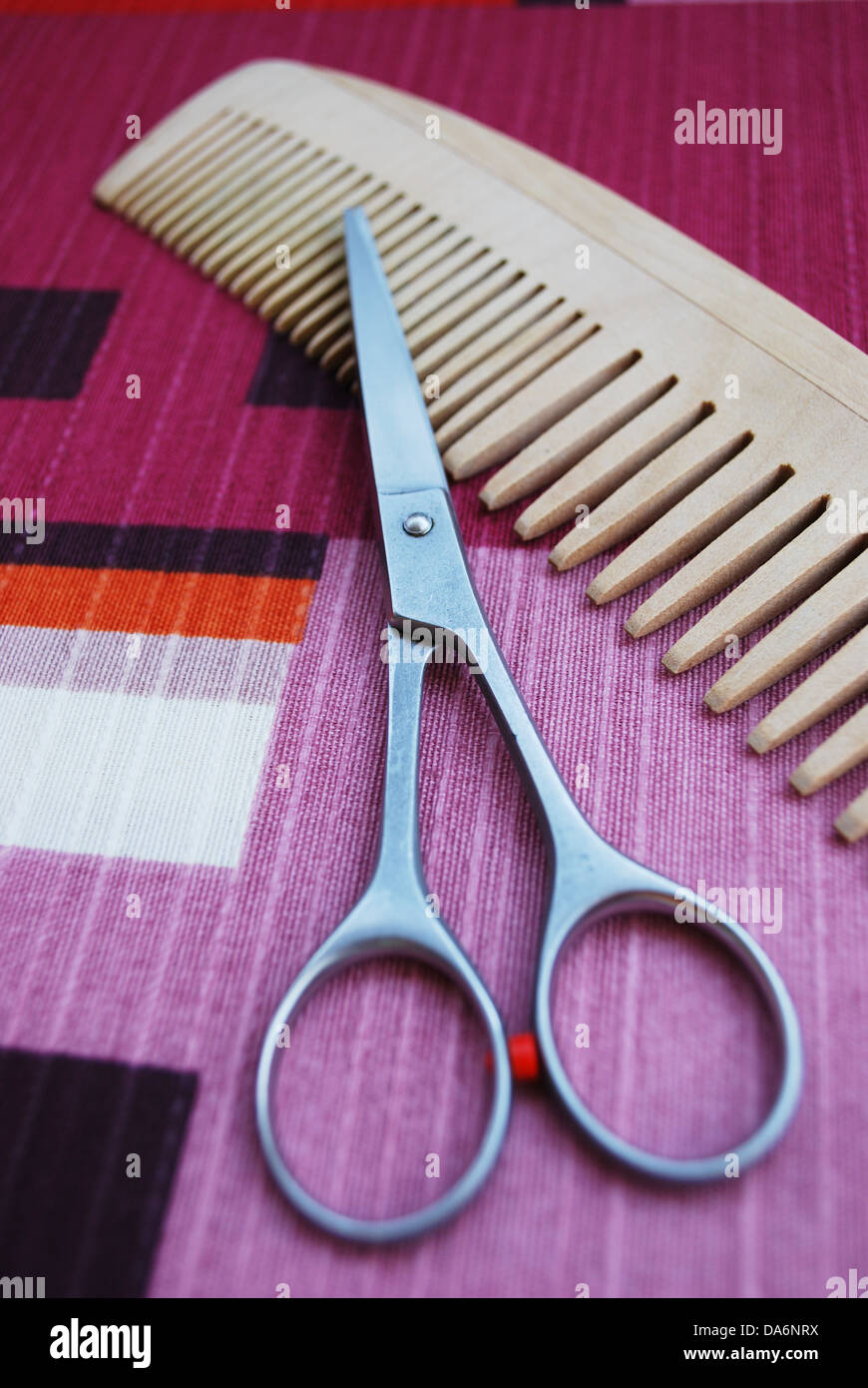 Professional scissors and wooden comb on colorful background Stock ...