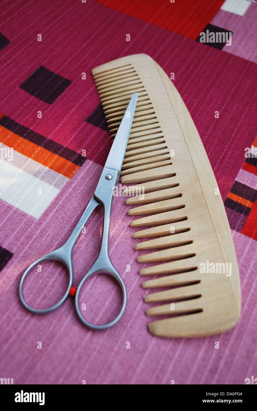 Professional scissors and wooden comb on colorful background Stock ...