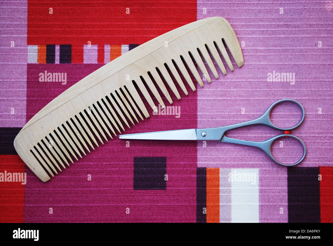 Professional scissors and wooden comb on colorful background Stock ...