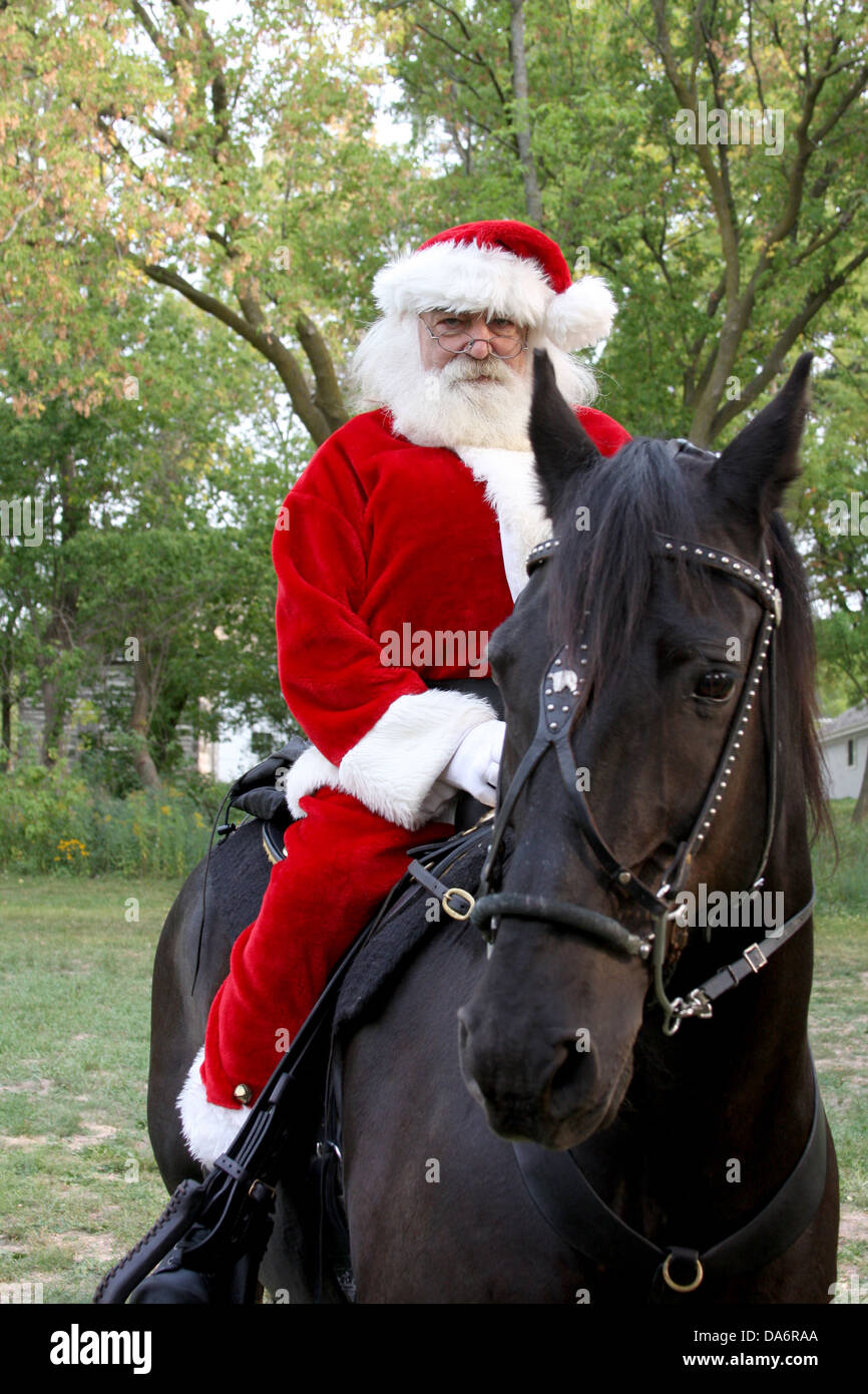 Santa riding a black horse Stock Photo - Alamy