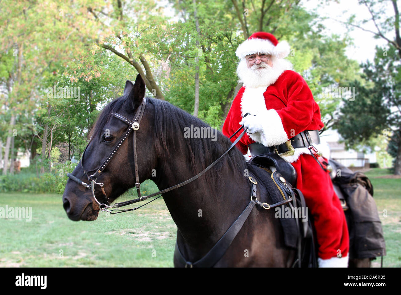 Santa riding a black horse Stock Photo - Alamy