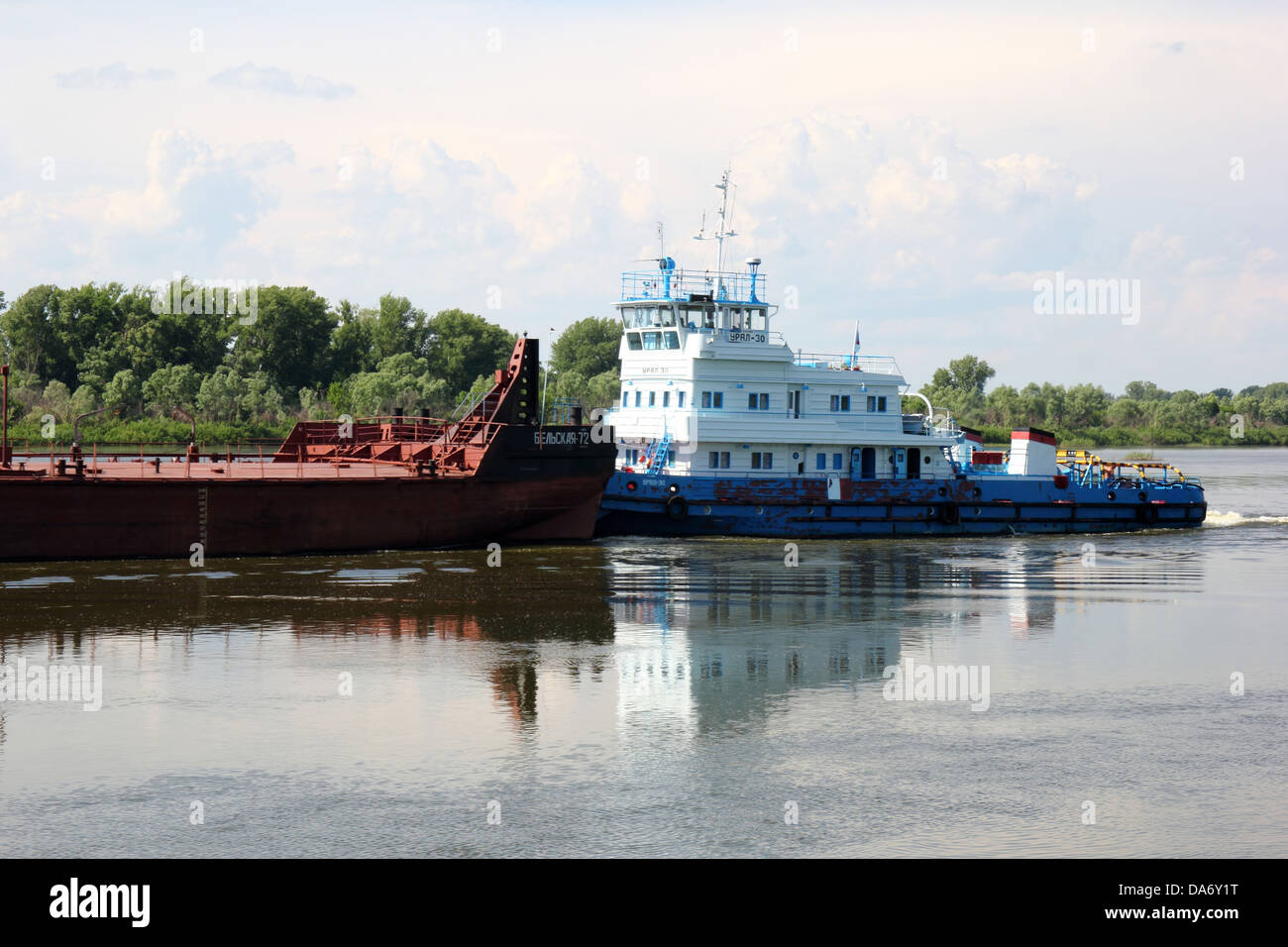 barge floating down the river in a forest and sky Stock Photo - Alamy
