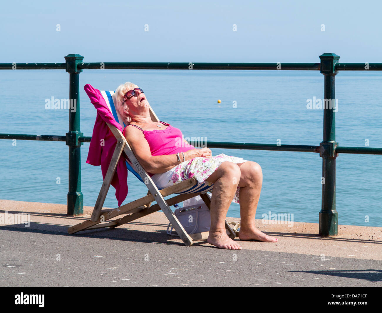 Sidmouth, Devon, UK. 5th July, 2013. Woman sleeping on a deck chair ...