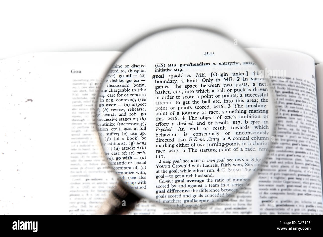 A magnifying glass on the word goal on a dictionary Stock Photo - Alamy