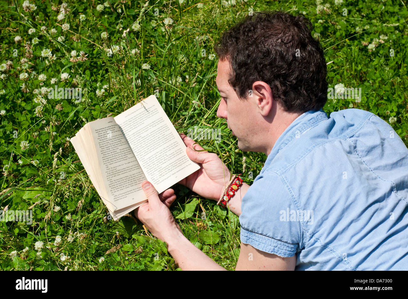 A man reading a book in his garden in summer Stock Photo - Alamy