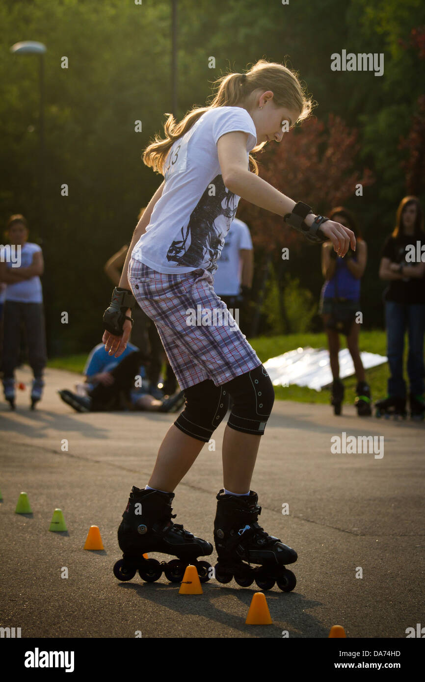 Teenage girl roller blading through slalom cones Stock Photo - Alamy