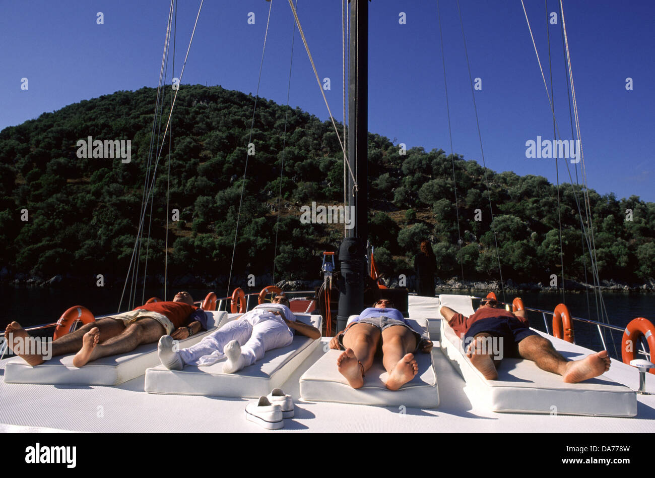 Vacationers sunbathing on a yacht along the shoreline of the Turkish ...