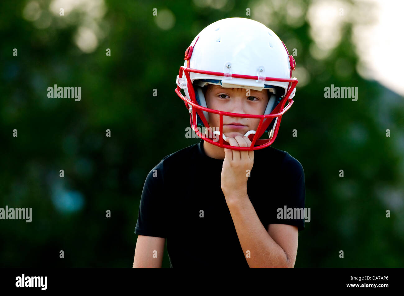 Young football boy in helmet with sad look on face Stock Photo - Alamy