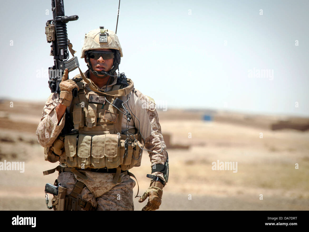 A US Marine provides security during a distribution of radios and comic ...