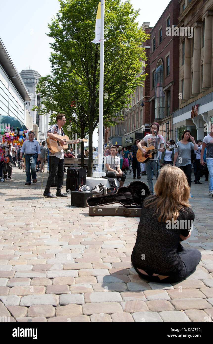 A Manchester city street scene on warm sunny day with shoppers and ...
