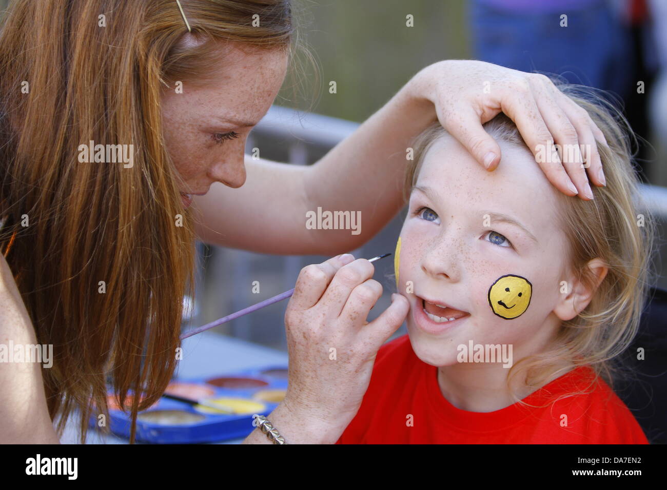Dublin, Ireland. 6th July 2013. A woman paints a little smiley (the ...