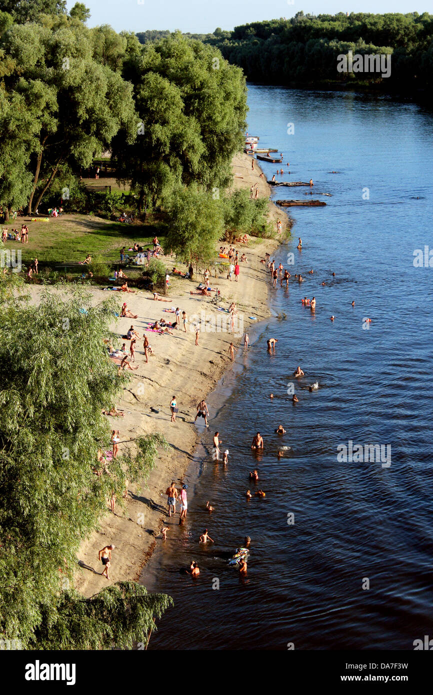 beautiful landscape with river and many people bathing near the beach ...